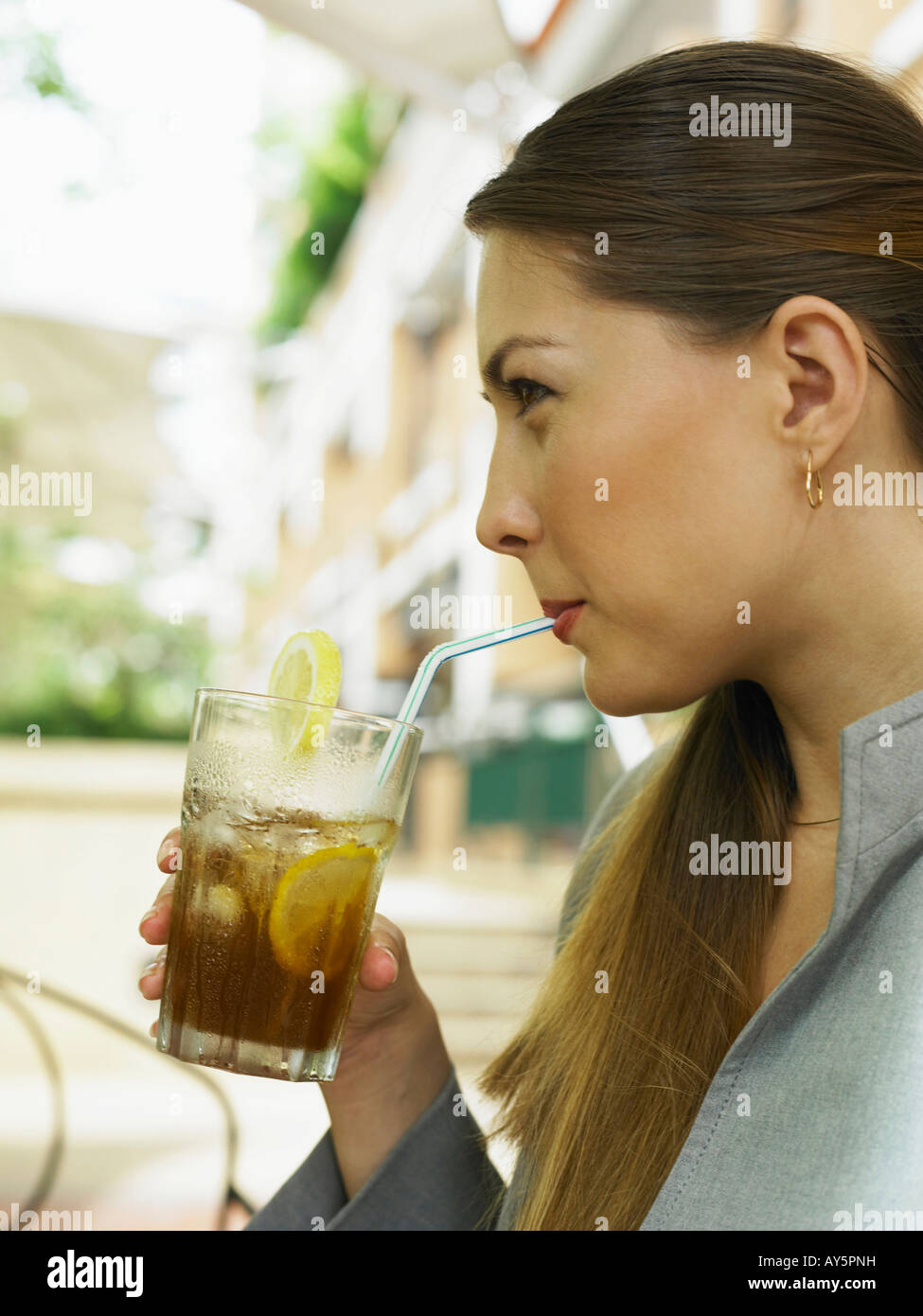 Young business women sipping her drink with a straw Stock Photo - Alamy