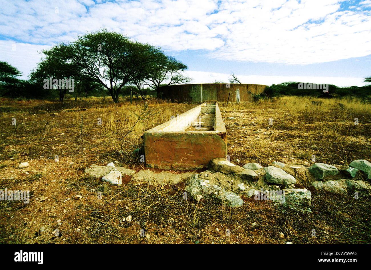 Dramatic dry landscape, empty animal water trough, arid African farm ...
