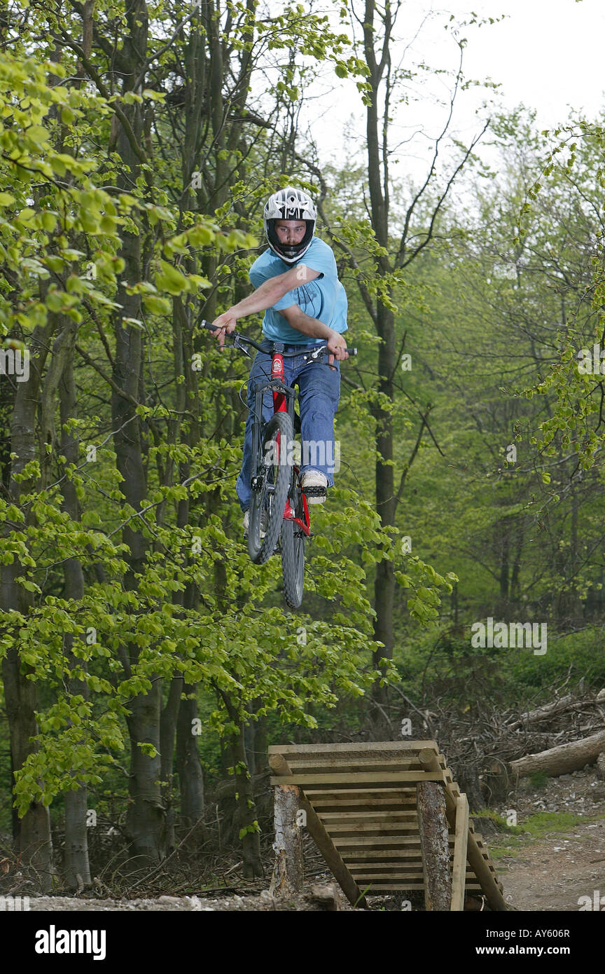 A mountain biker performs a stunt off a wooden ramp Stock Photo - Alamy
