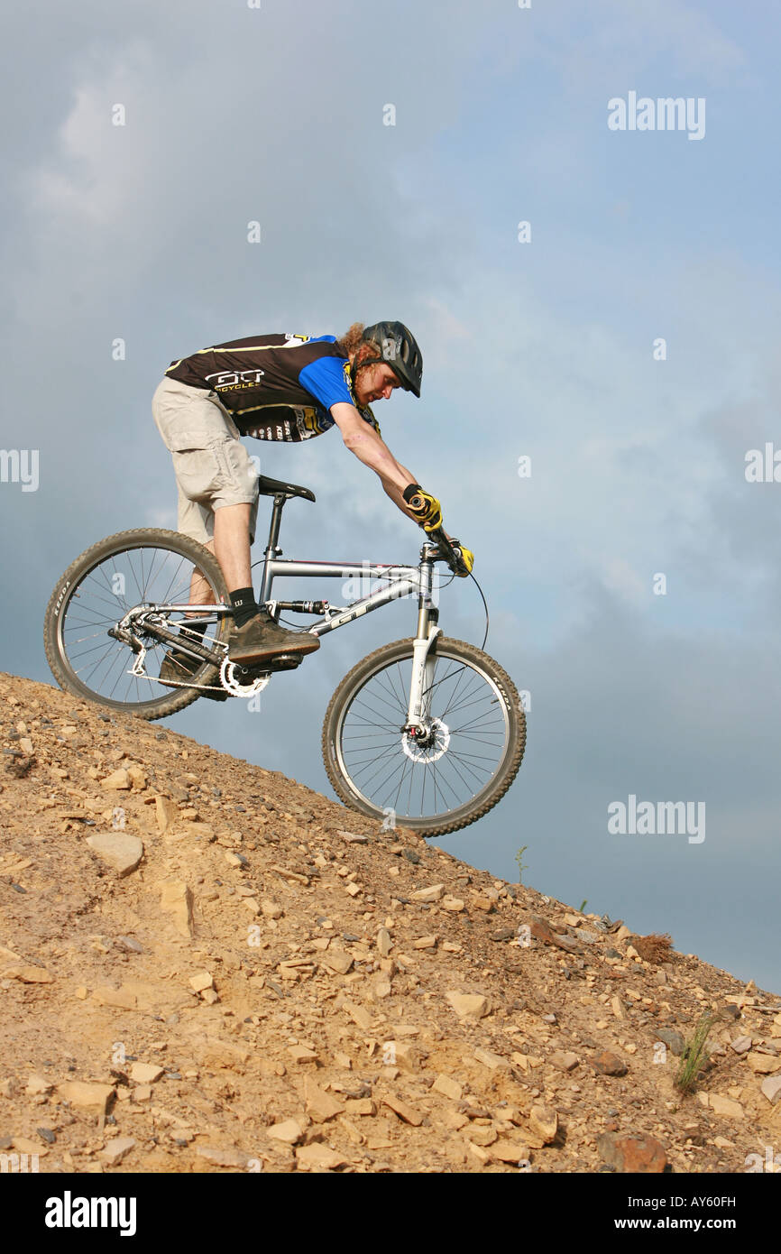 A mountain biker rides his mountain bike down a rocky slope Stock Photo ...