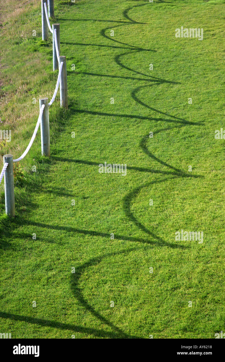 Shadows from a rope fence on green grass Stock Photo - Alamy