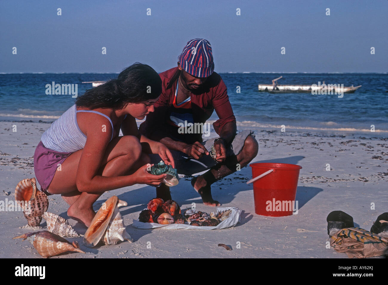 Woman tourist buying exotic shells from beach trader Diani Kenya Stock ...