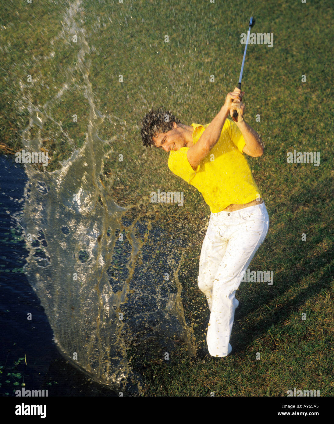 man golfer swings at ball in water trap Stock Photo - Alamy