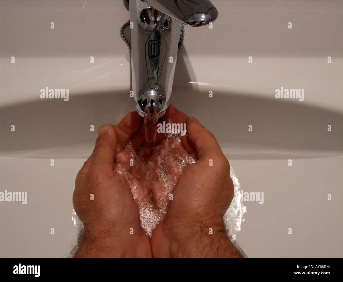 Man cleaning his hands in a wash basin Stock Photo - Alamy