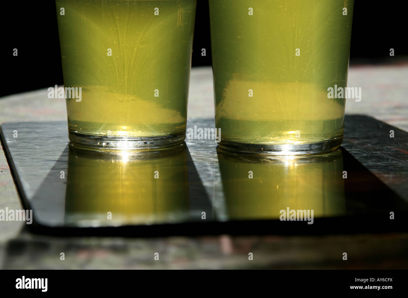 Pair of pint drinks glasses together containing lime coloured drink ...