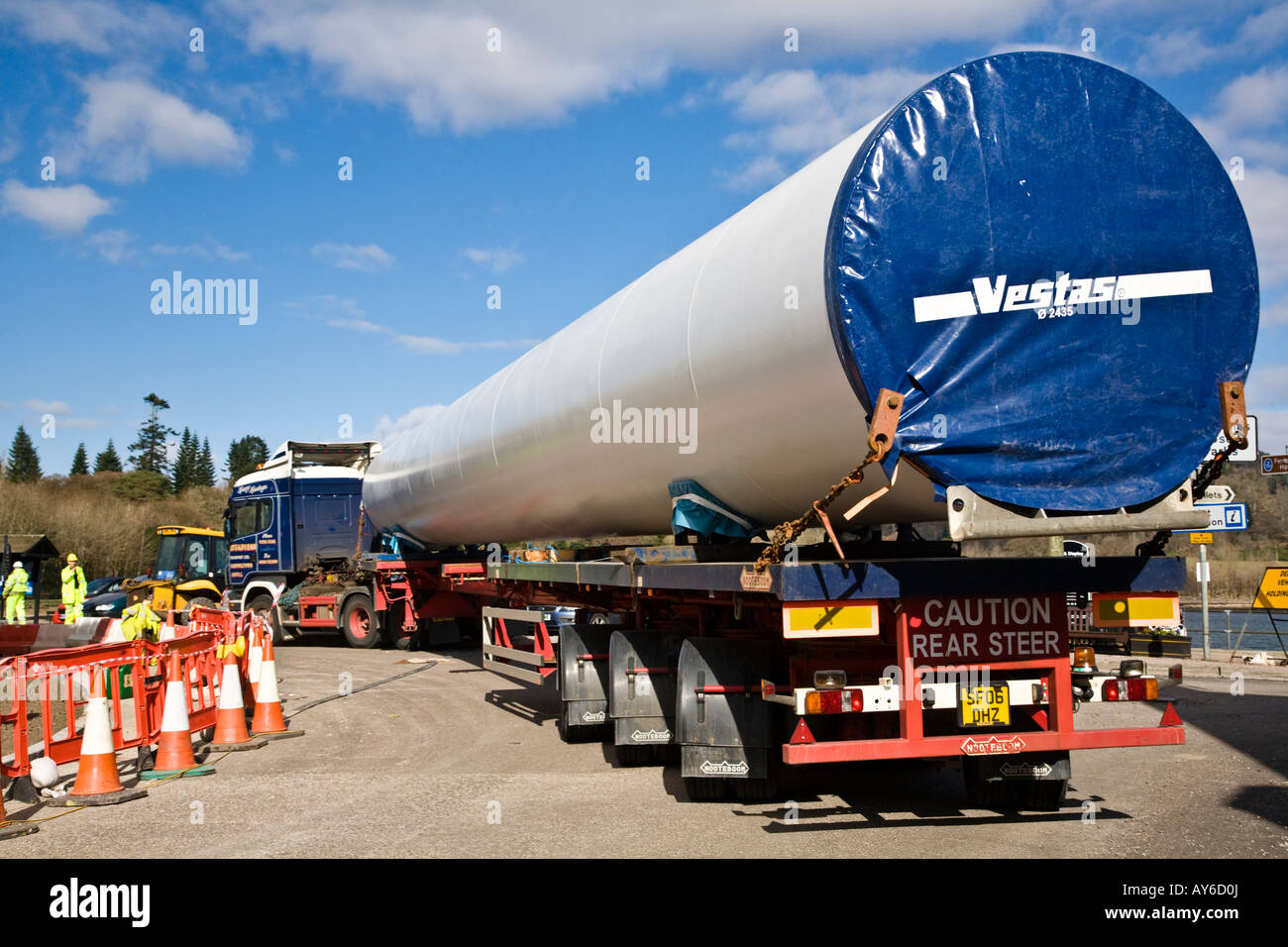 A lorry transporting a wind turbine support tower through a set of road ...