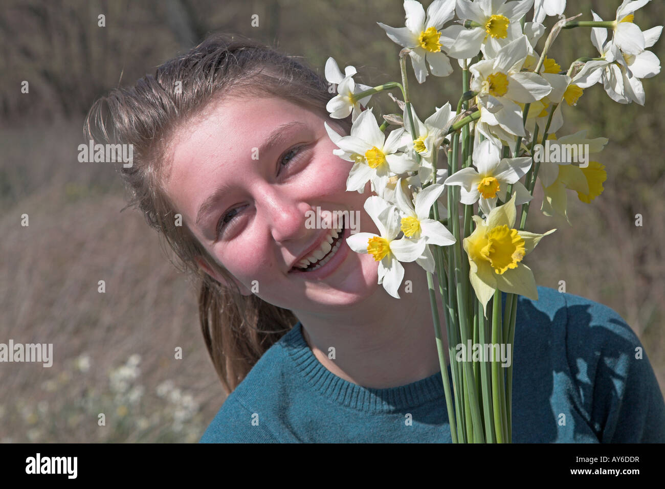 Young girl smiles holding bunch of freshly picked daffodils in ...
