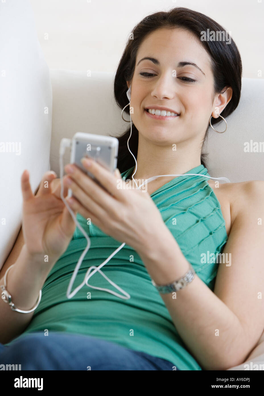 Young woman listening to mp3 player Stock Photo - Alamy