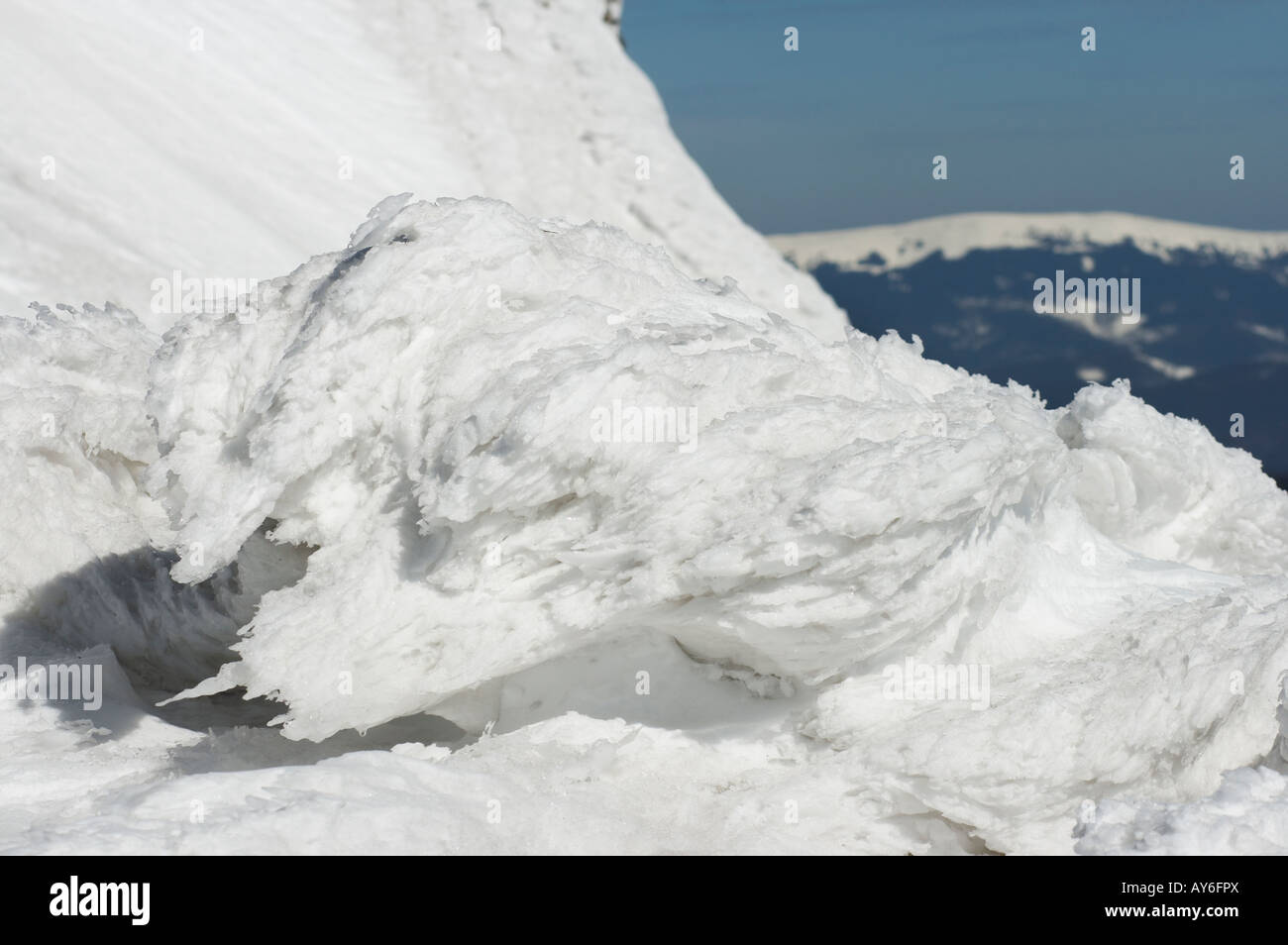 Wind form ice lumps on precipice brink and winter mountain behind not ...