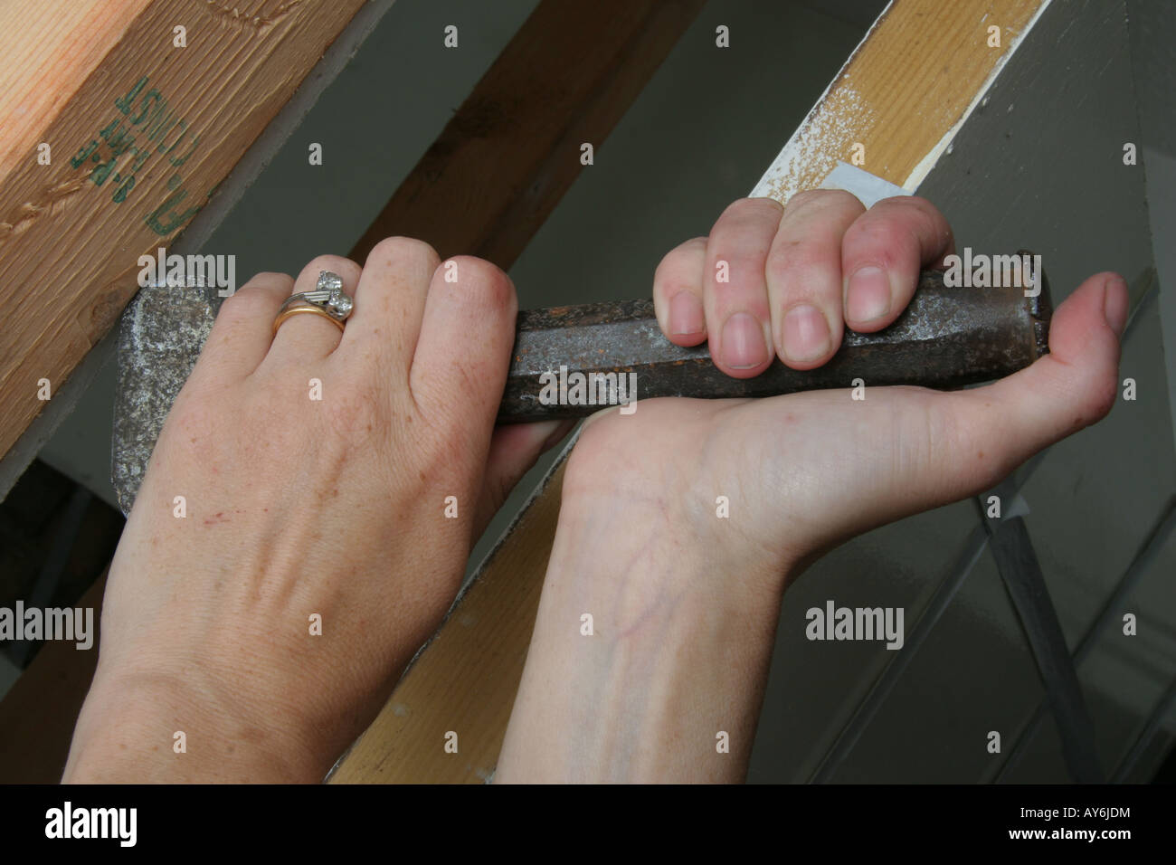 Woman's hands using chisel to remove plaster from wall Stock Photo - Alamy