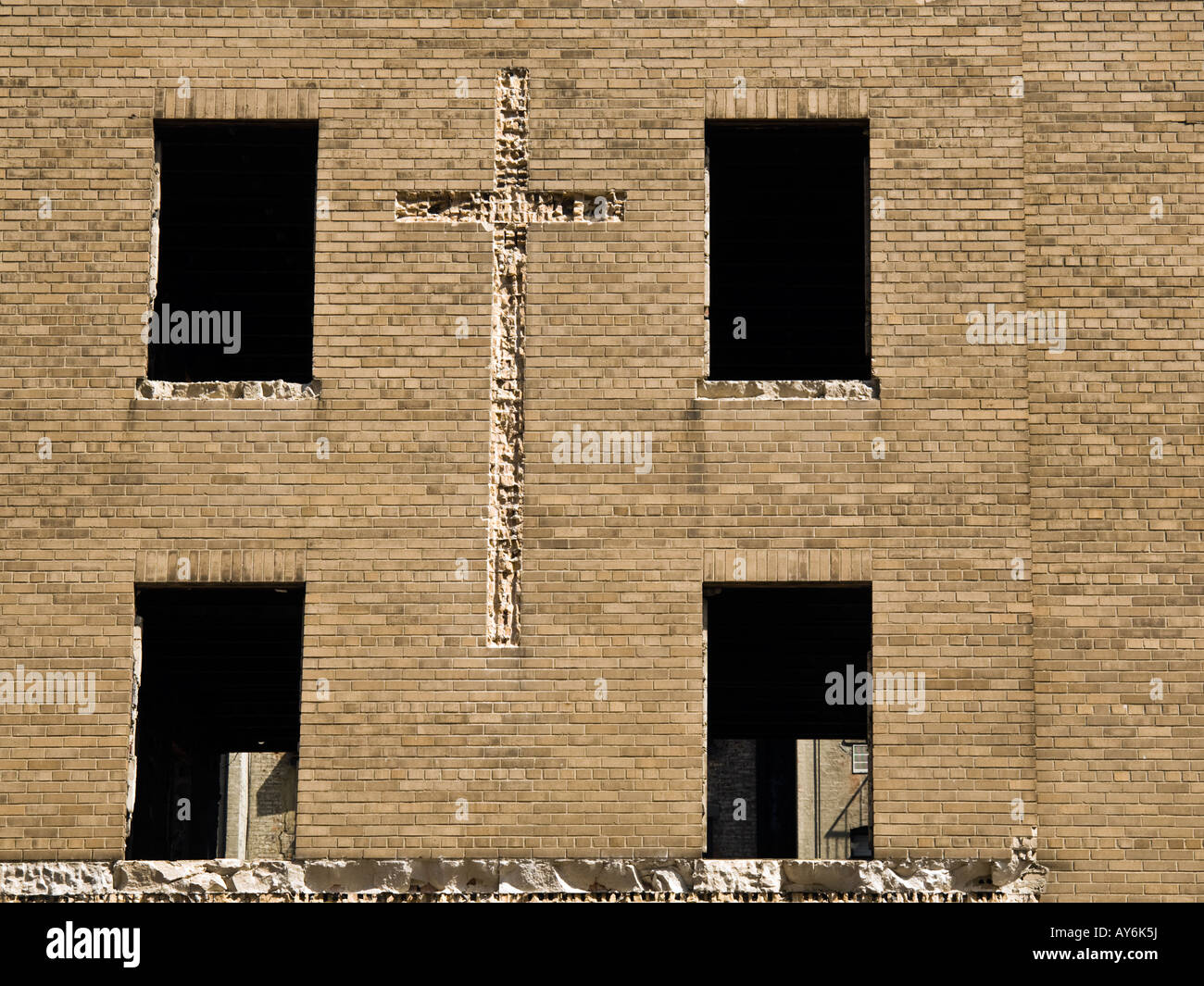 Chiseled imprint of a cross in the brick facade of vacant windowless ...