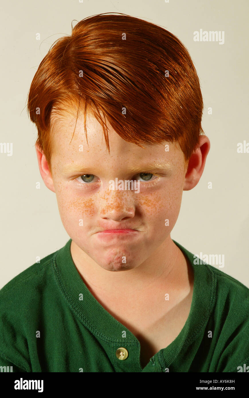 An angry 5 year old red headed Caucasian boy in a green shirt from ...