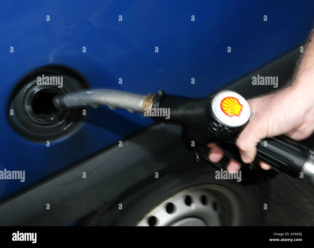 A man fills up his car at a petrol pump at an Shell service station in ...