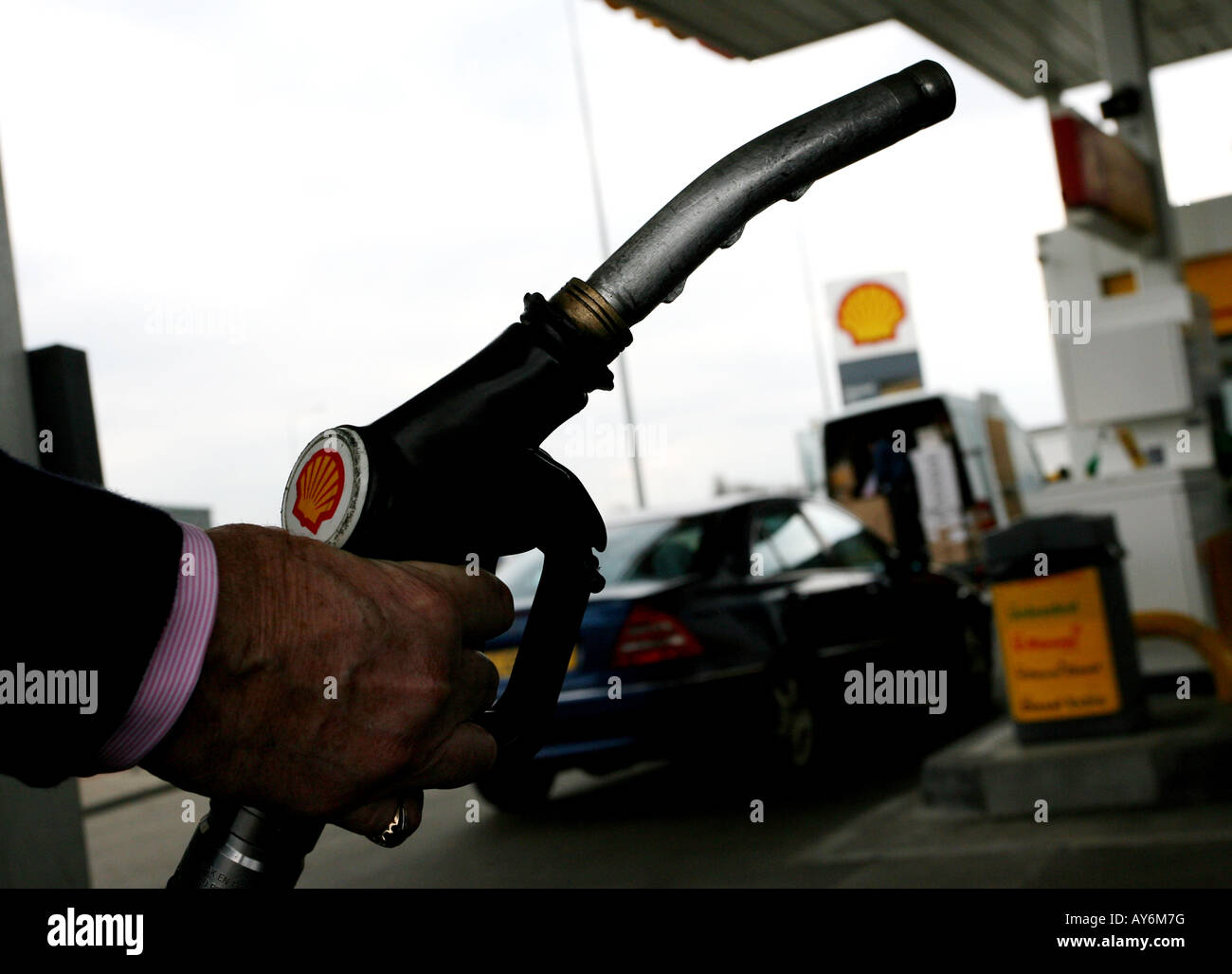 A man fills up his car at a petrol pump at an Shell service station in ...