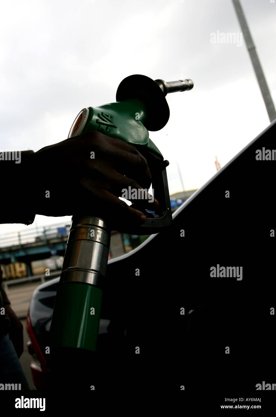 A man fills up his car at a petrol pump at an Shell service station in ...