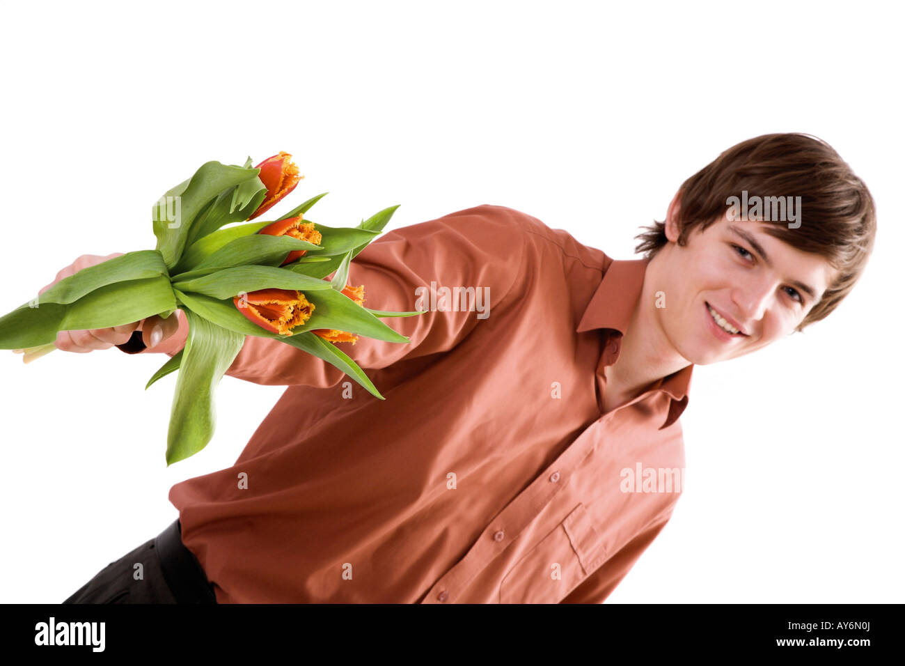 Young man offering flowers Stock Photo - Alamy