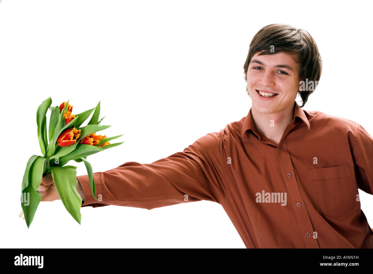 Young man offering flowers Stock Photo - Alamy