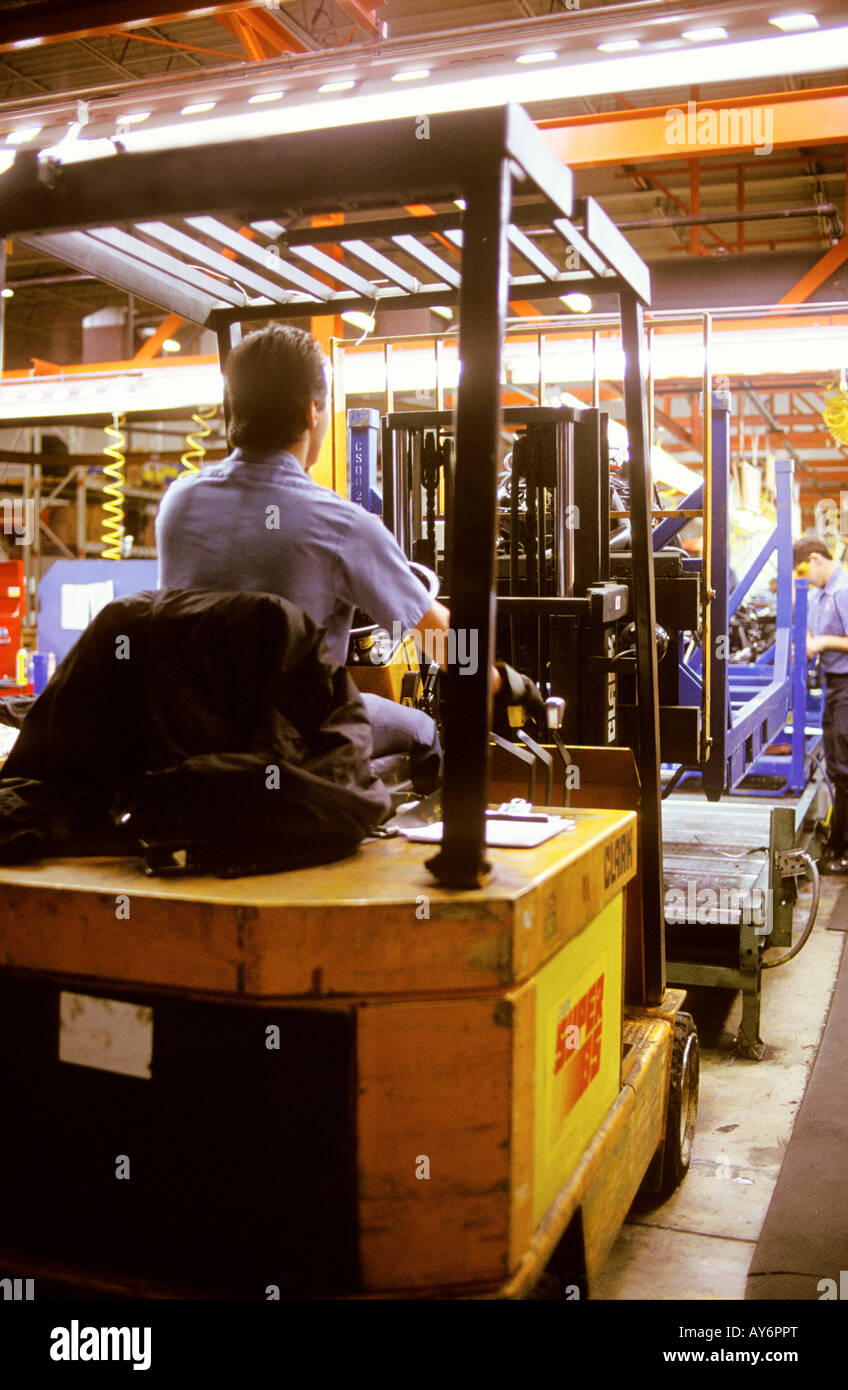 A fork lift driver prepares to place a diesel engine onto an assembly ...