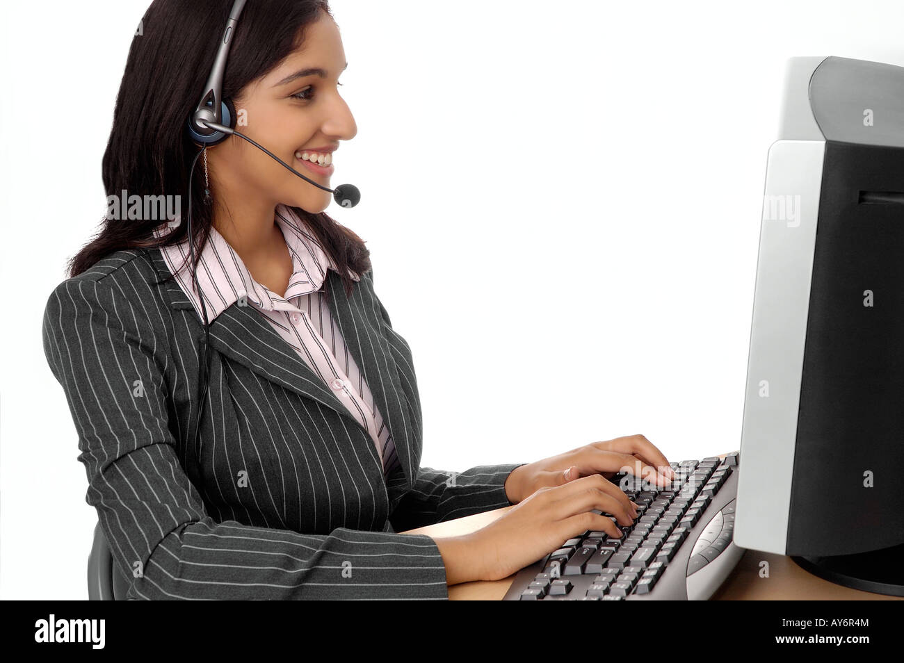 Attractive woman at computer with headset; customer service or ...