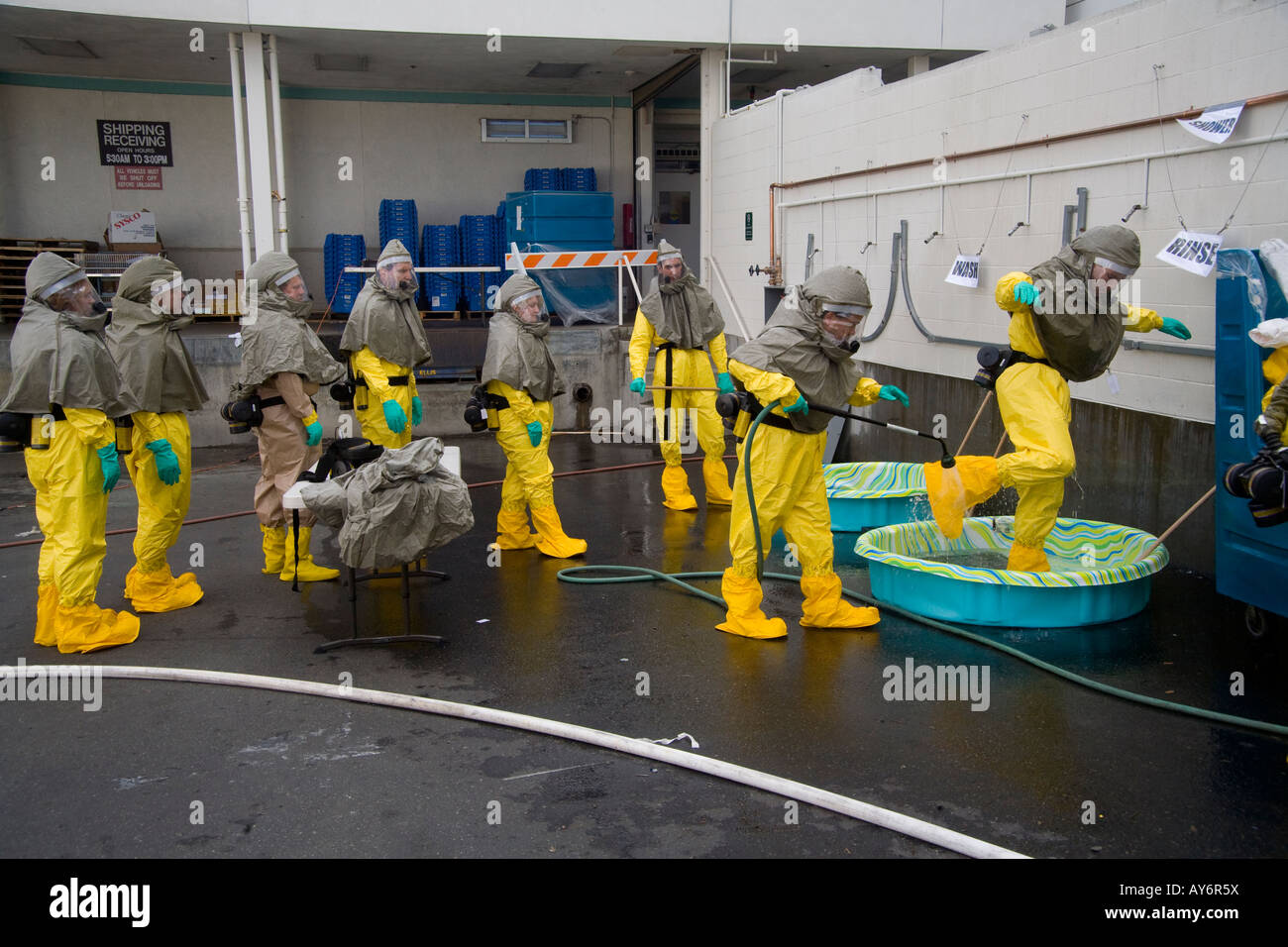 Volunteers in protective clothing are decontaminated during a drill ...