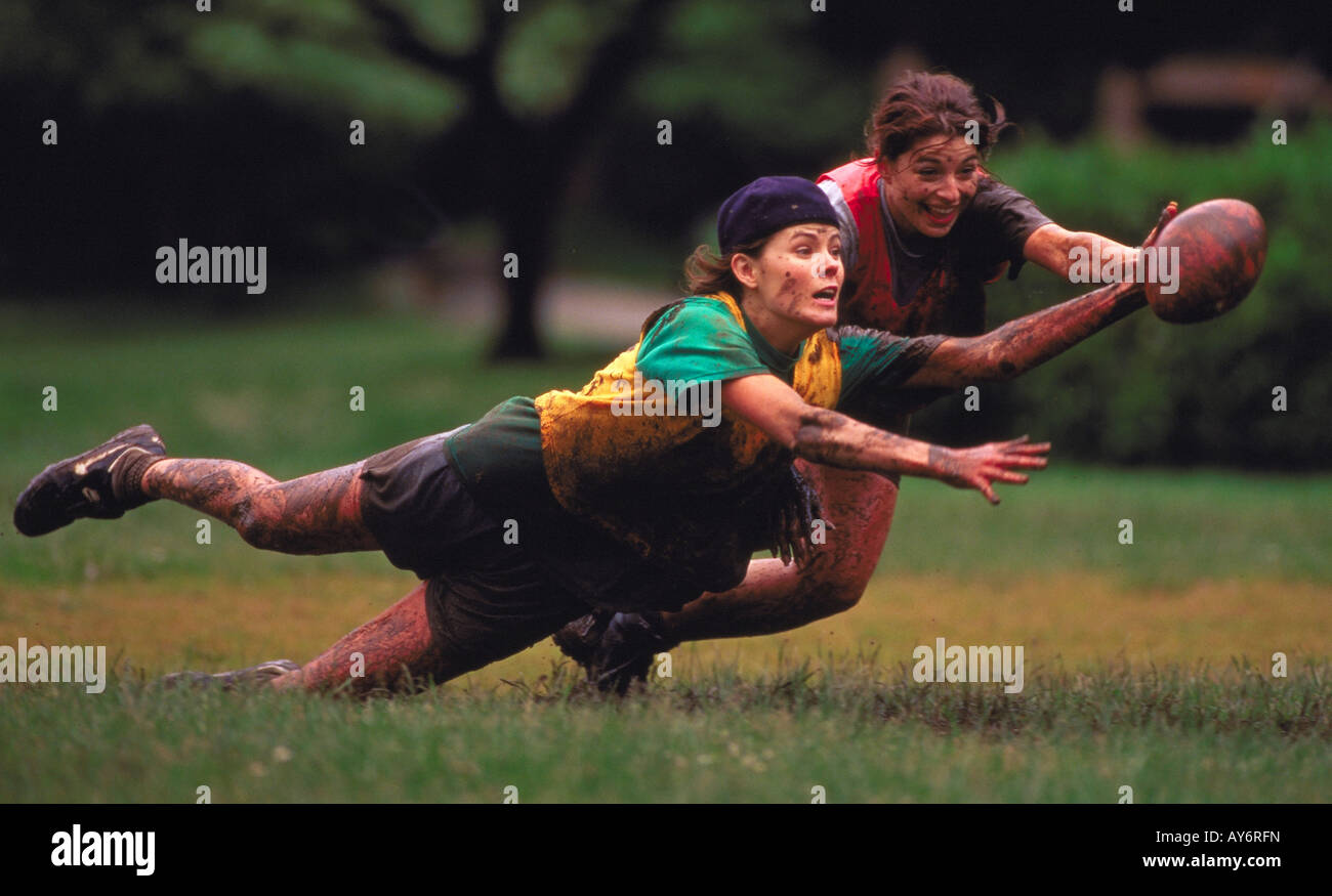 Two young women fight for the football in a game of touch football on a ...