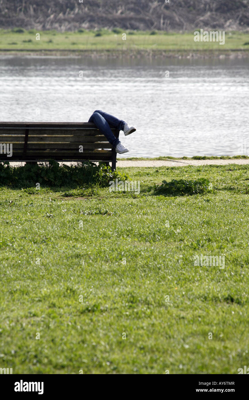 young woman lying on bench in park Stock Photo - Alamy