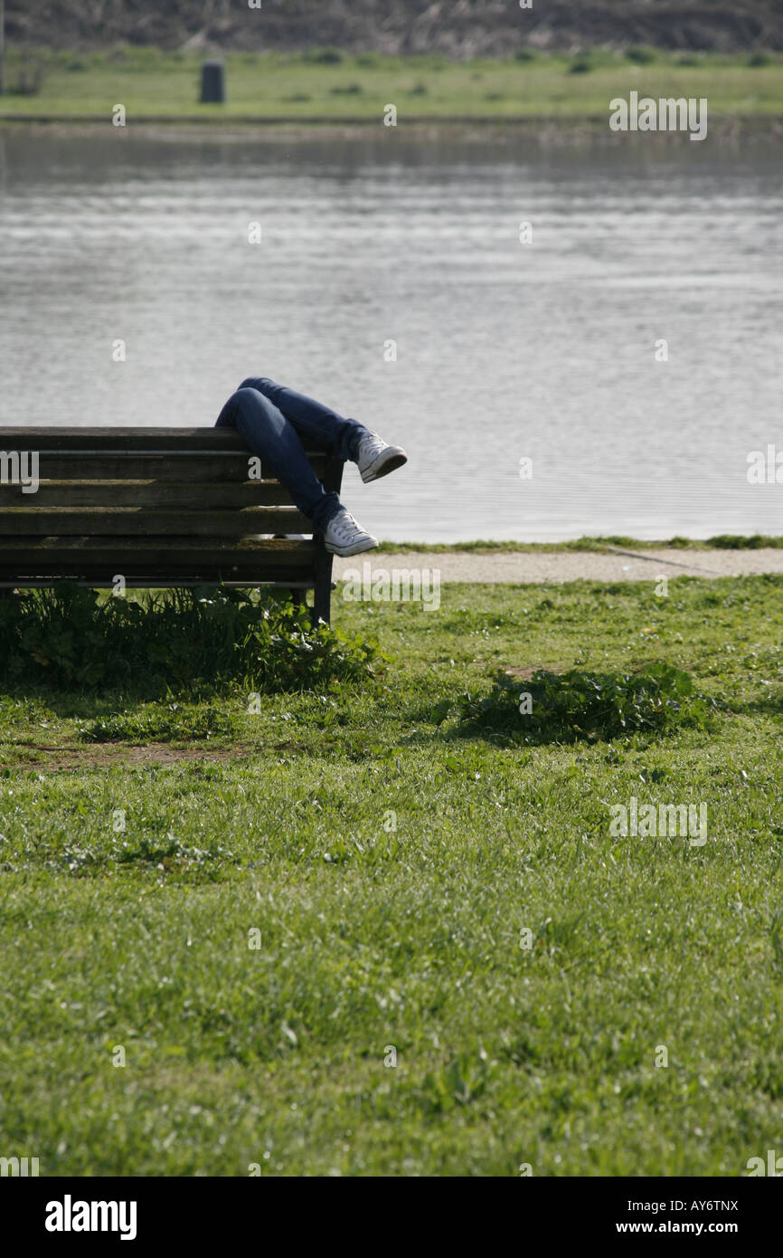 young woman lying on bench in park Stock Photo - Alamy