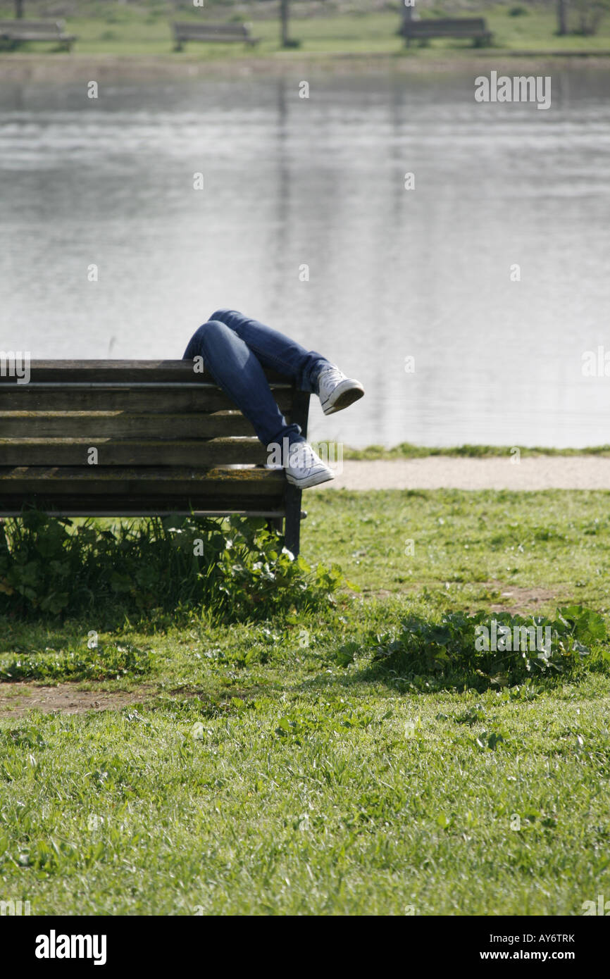 young woman lying on bench in park Stock Photo - Alamy