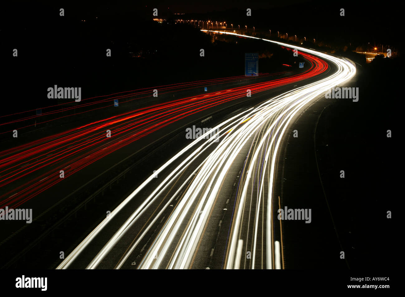 The M25 motorway at night. A long exposure shows the flow of traffic ...