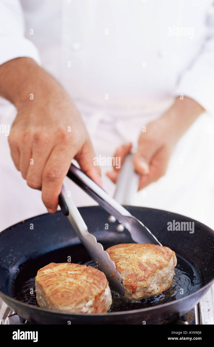 Chef cooking two fish steaks Stock Photo - Alamy