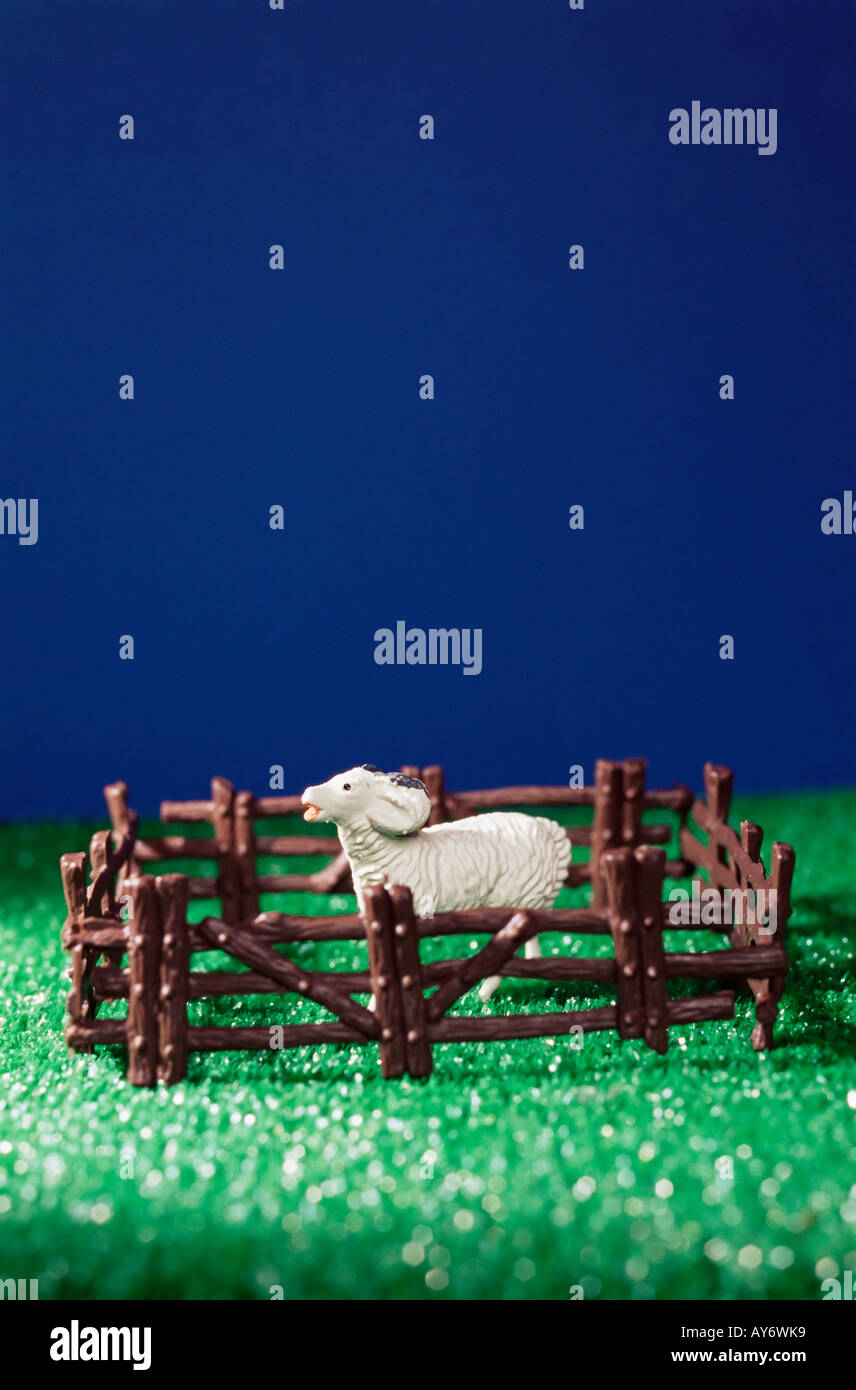 Toy sheep in plastic fence Stock Photo - Alamy