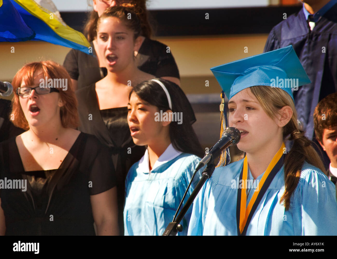 A high school choral group sings during commencement exercises in ...