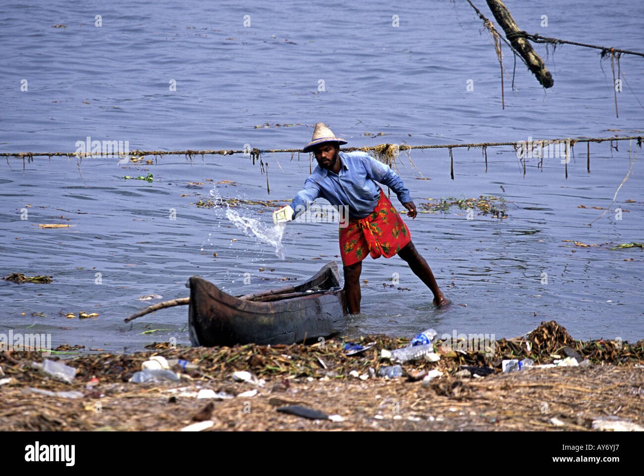Fisherman cleaning out his canoe in Cochin India Stock Photo - Alamy