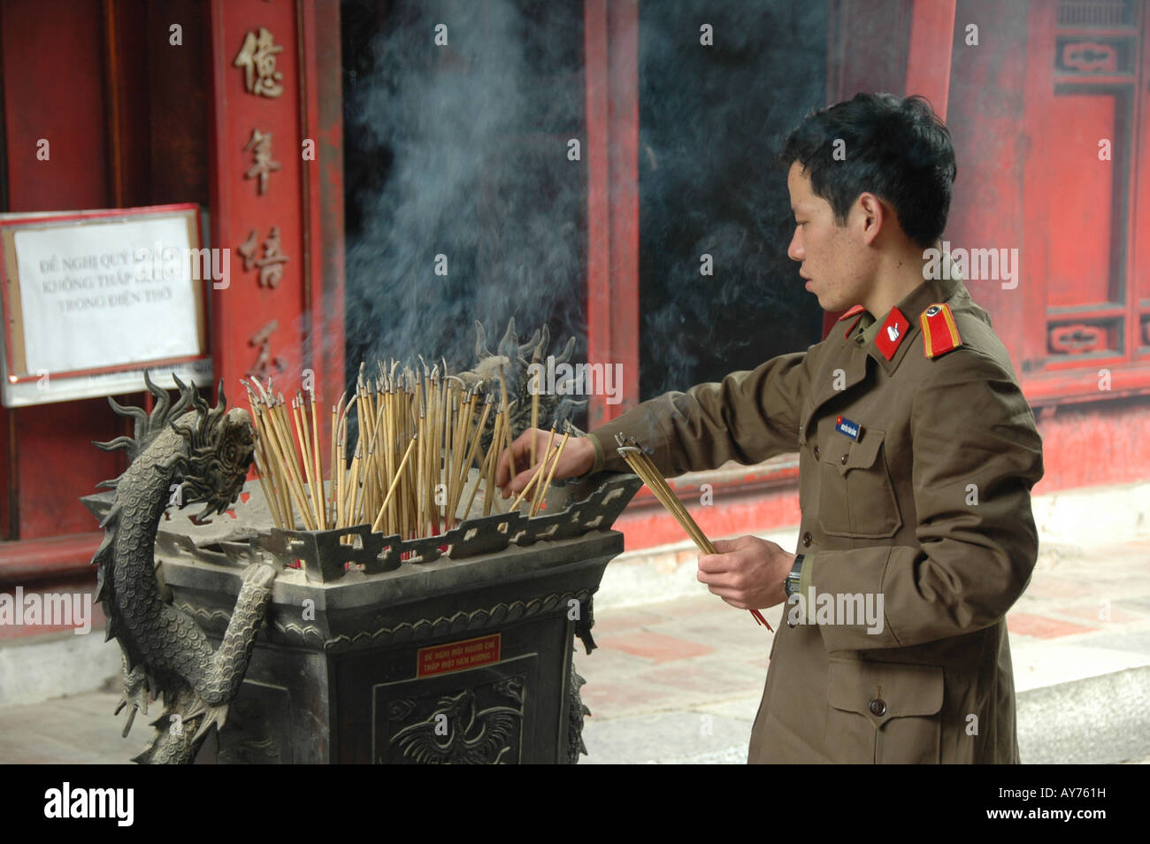 Soldier making an offering before a Buddhist shrine at the Temple of ...