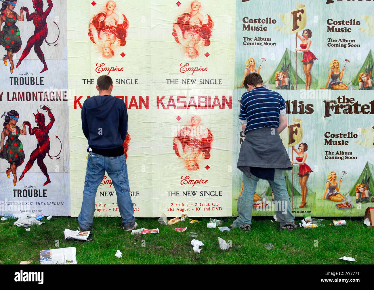 Two men urinating against a wall at a music festival Stock Photo - Alamy