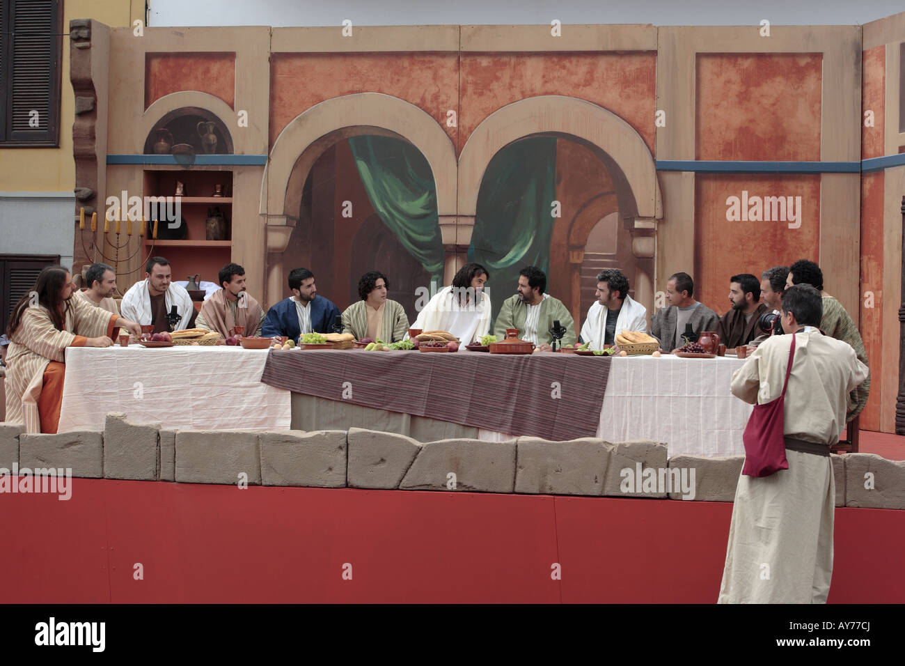 Actors playing Jesus and his 12 disciples sit down to enact the last ...