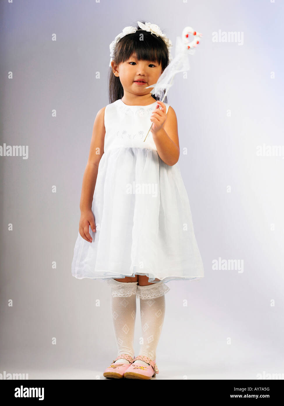Sweet little girl standing with her magic stick Stock Photo - Alamy