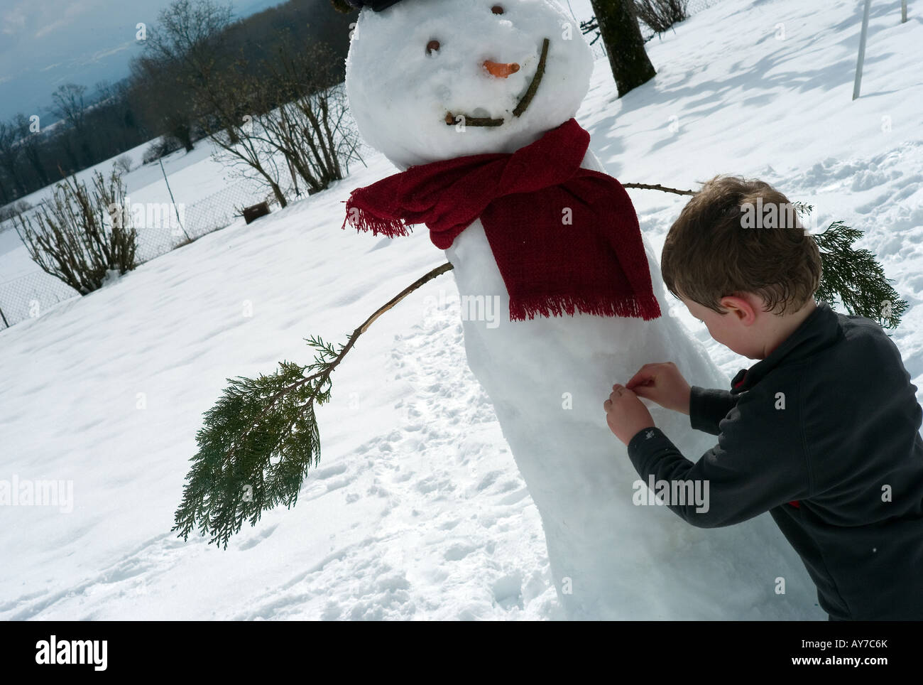 Boy building a snowman Stock Photo - Alamy