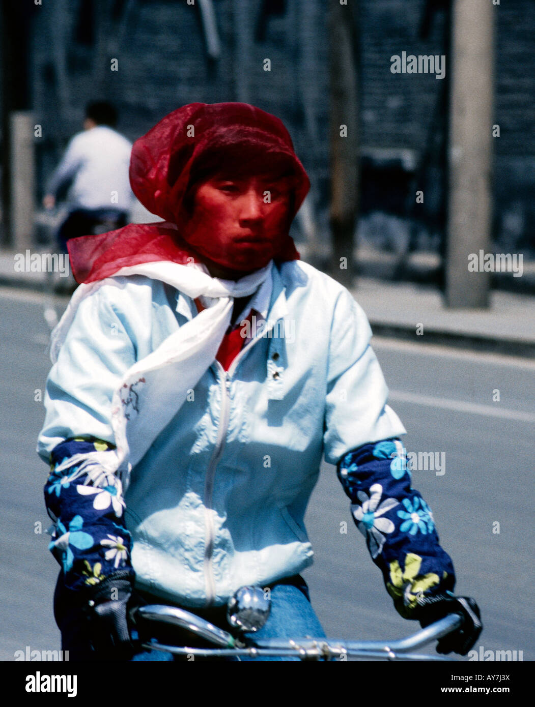 Beijing woman bicyclist wearing sheer scarf over face for protection ...