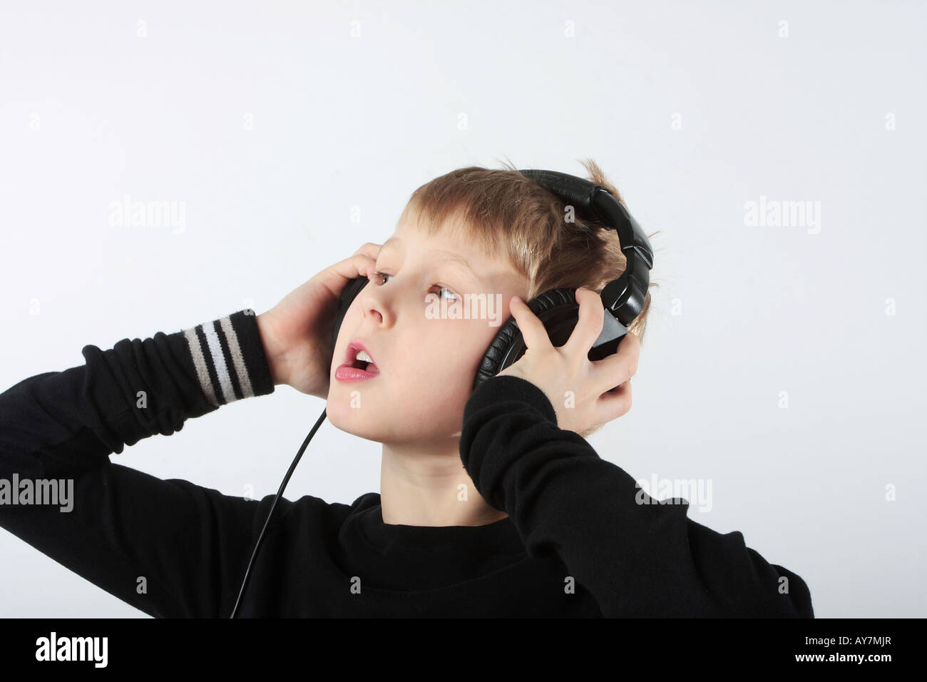 Young boy listening to music in headphones Stock Photo - Alamy