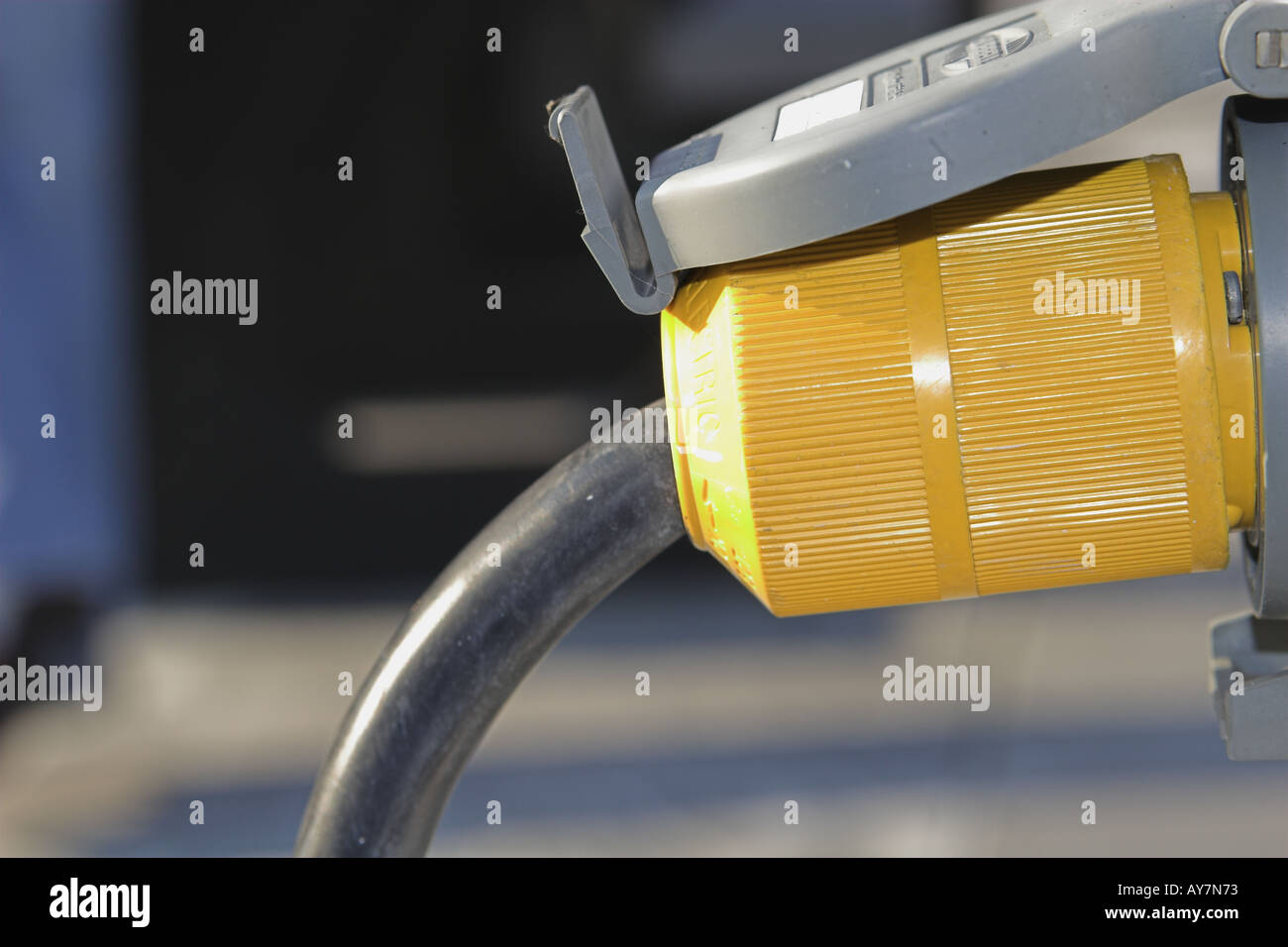 horizontal image of yellow power plug and black wire plugged into ...