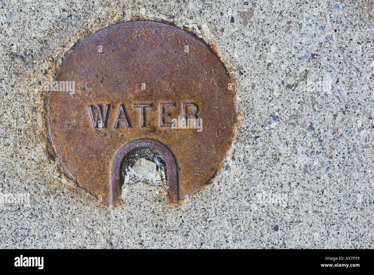 Horizontal image of rusted metal water cover in concrete sidewalk Stock ...