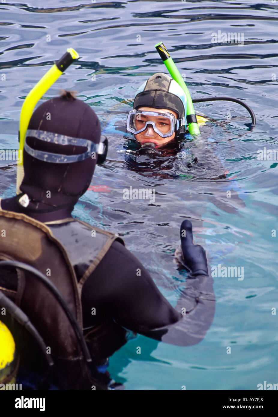 A diving instructor supervises a student during scuba school, at the ...