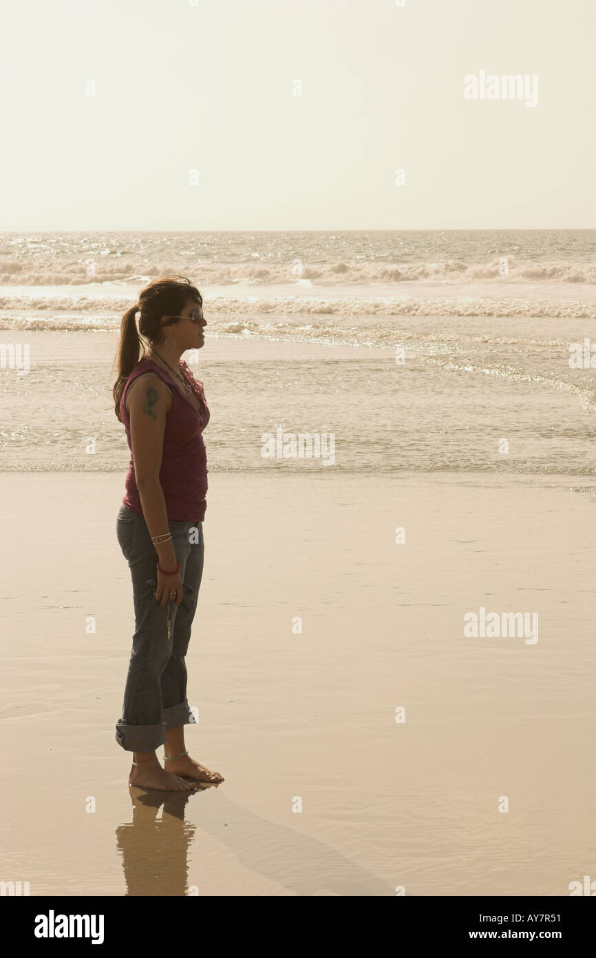 Young woman stands on beach Stock Photo - Alamy