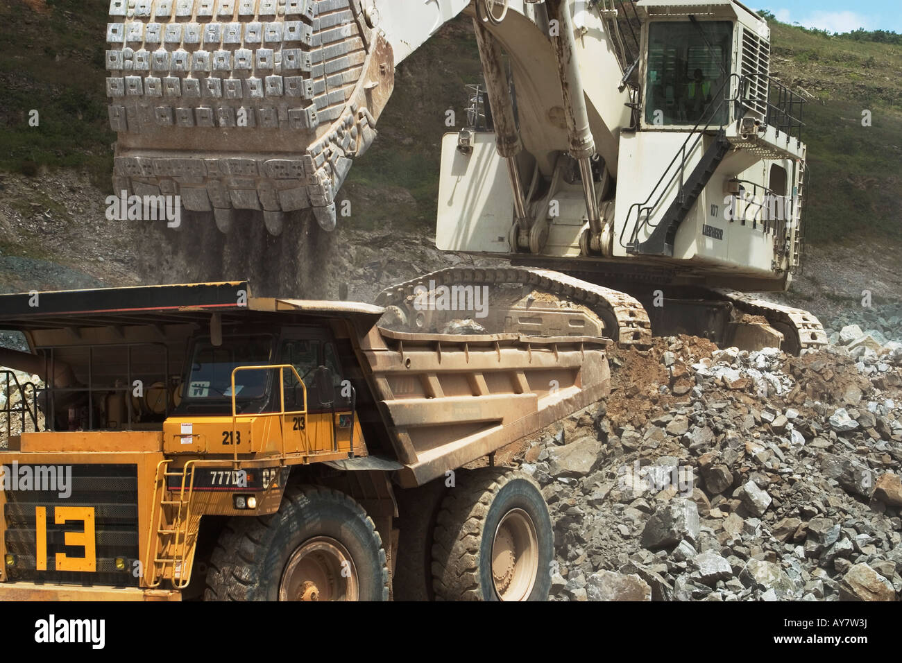 Close up of dumper truck being filled with gold ore body for transport ...