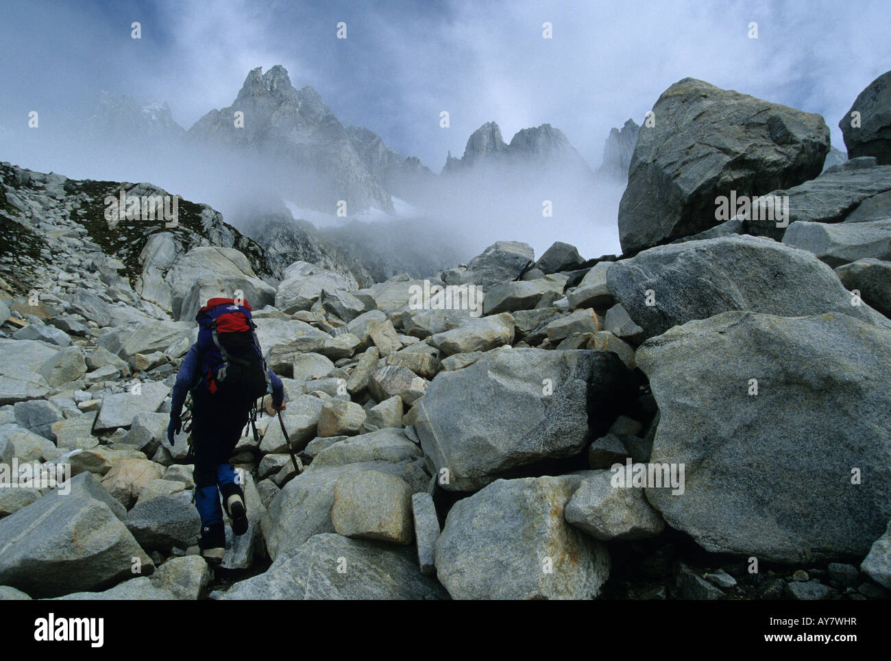 Fred Beckey hiking up a talus field in the Coast range of Canada Stock ...