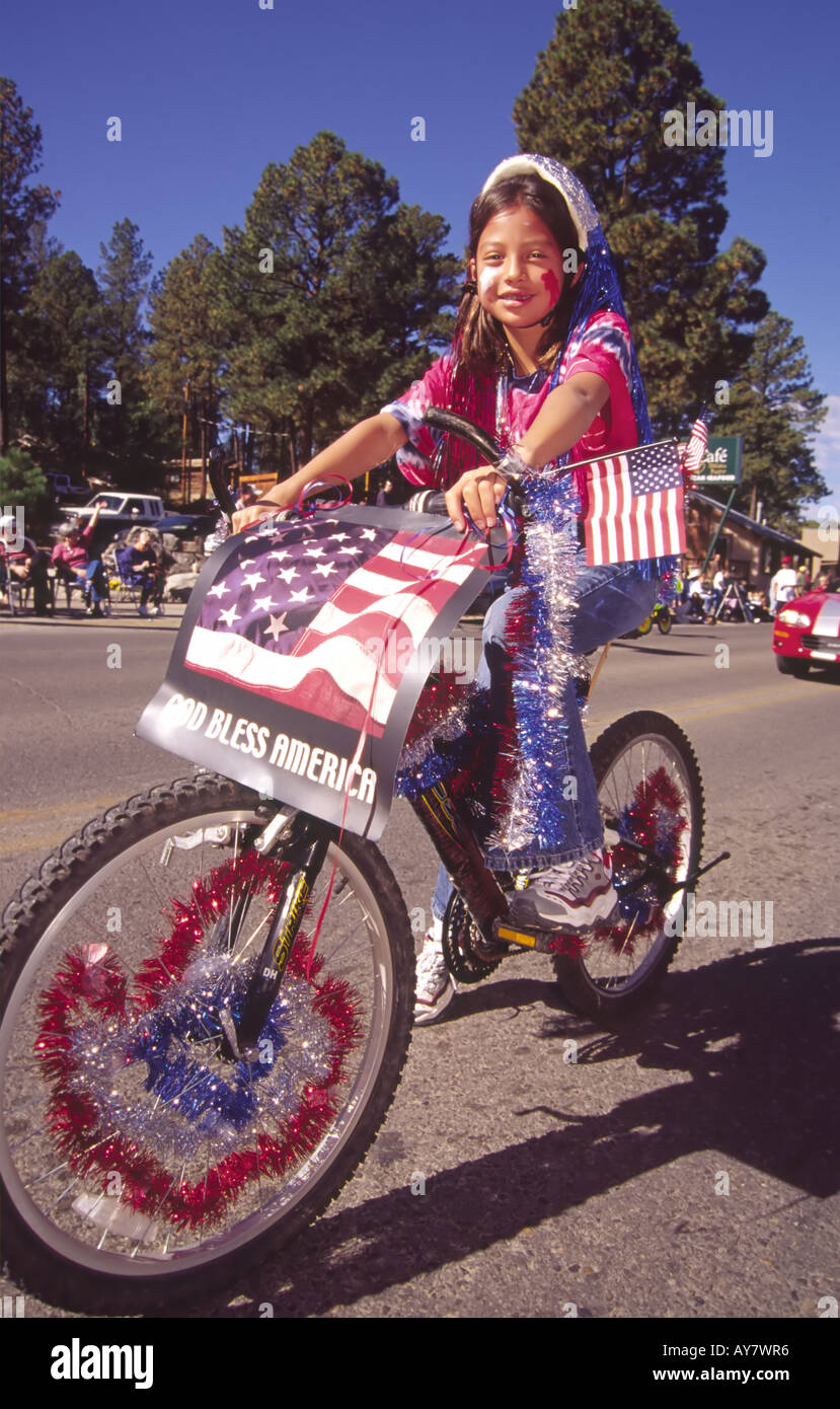 A patriotic young girl pedals her bicycle in the Aspenfest Parade, in ...