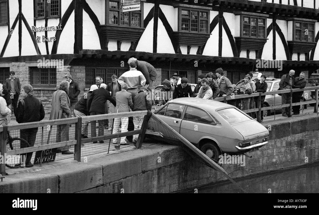 Car driven backwards through safety railings and overhanging river ...