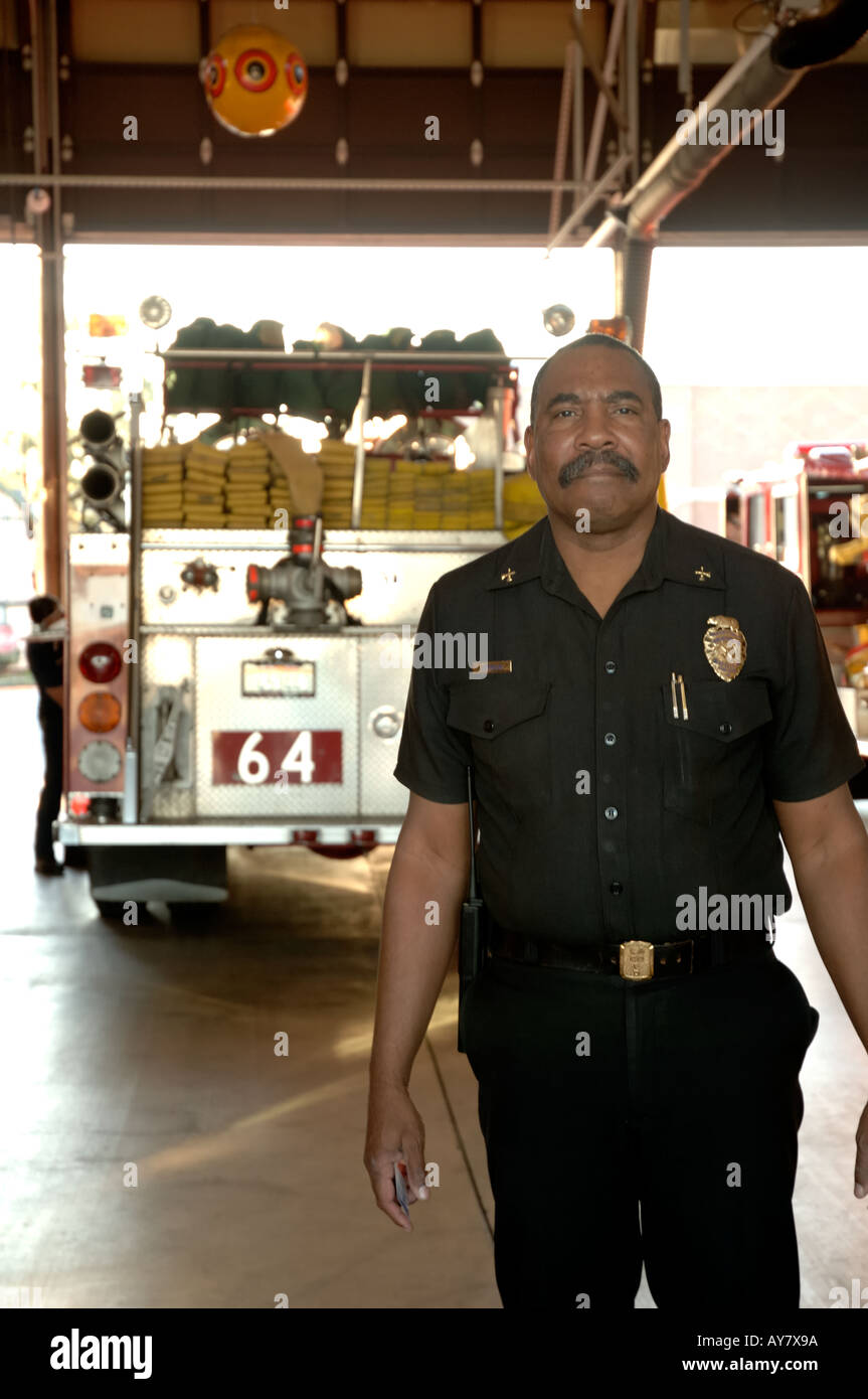 Portrait of African-American male firefighter standing inside fire ...