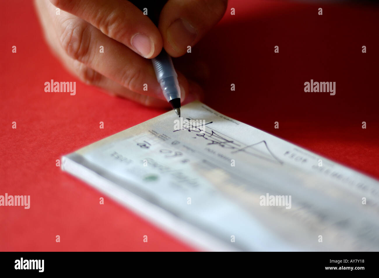 Man signing check Red background Stock Photo - Alamy